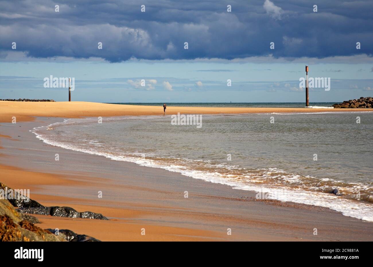 An early morning jogger on the beach in summer at the North Norfolk ...