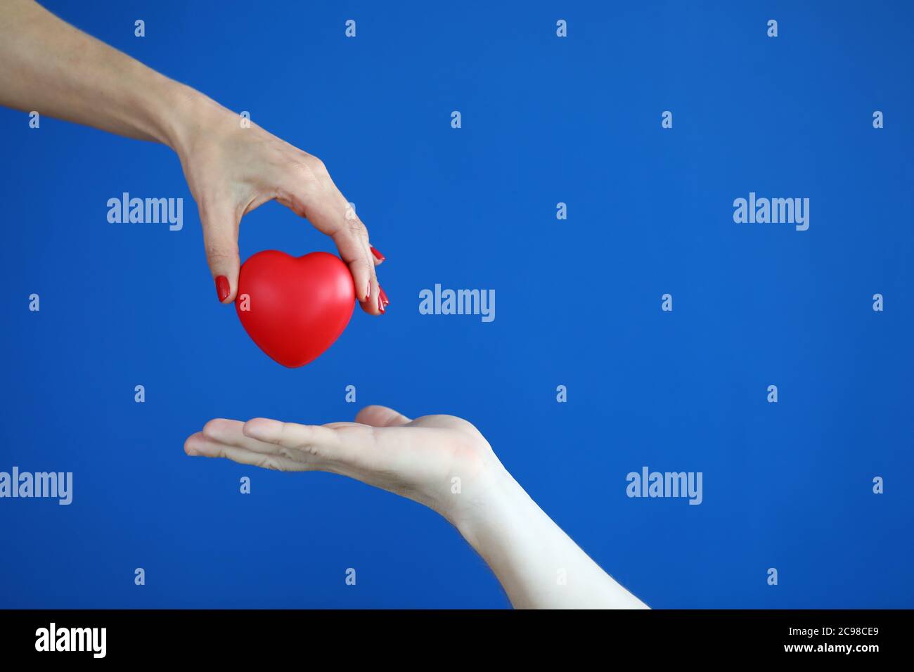 Hands pass red heart heart disease concept Stock Photo - Alamy