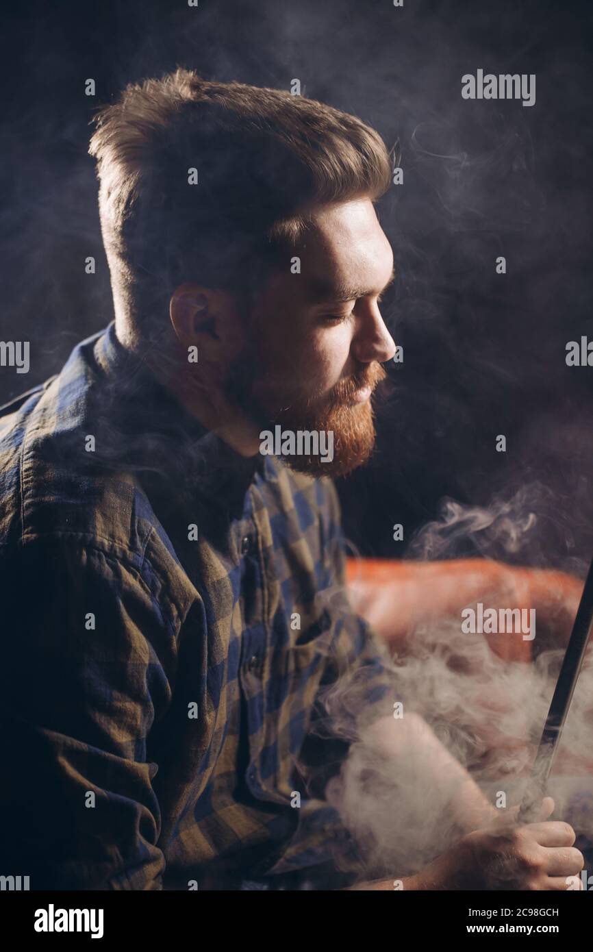 drunken young man smoking at the bar. close up side view photo ...