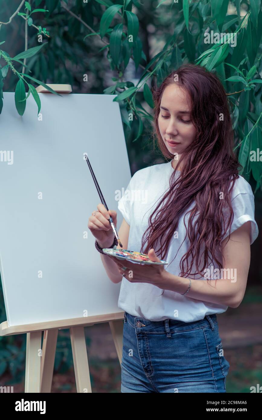 beautiful girl with long hair, artist holds a colored palette in his ...