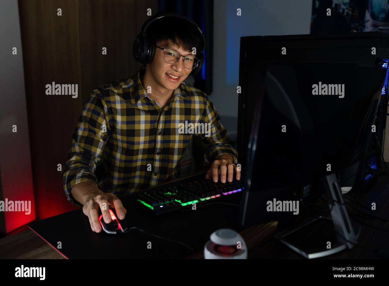 Handsome excited asian gamer guy in headphones enjoy and rejoicing ...