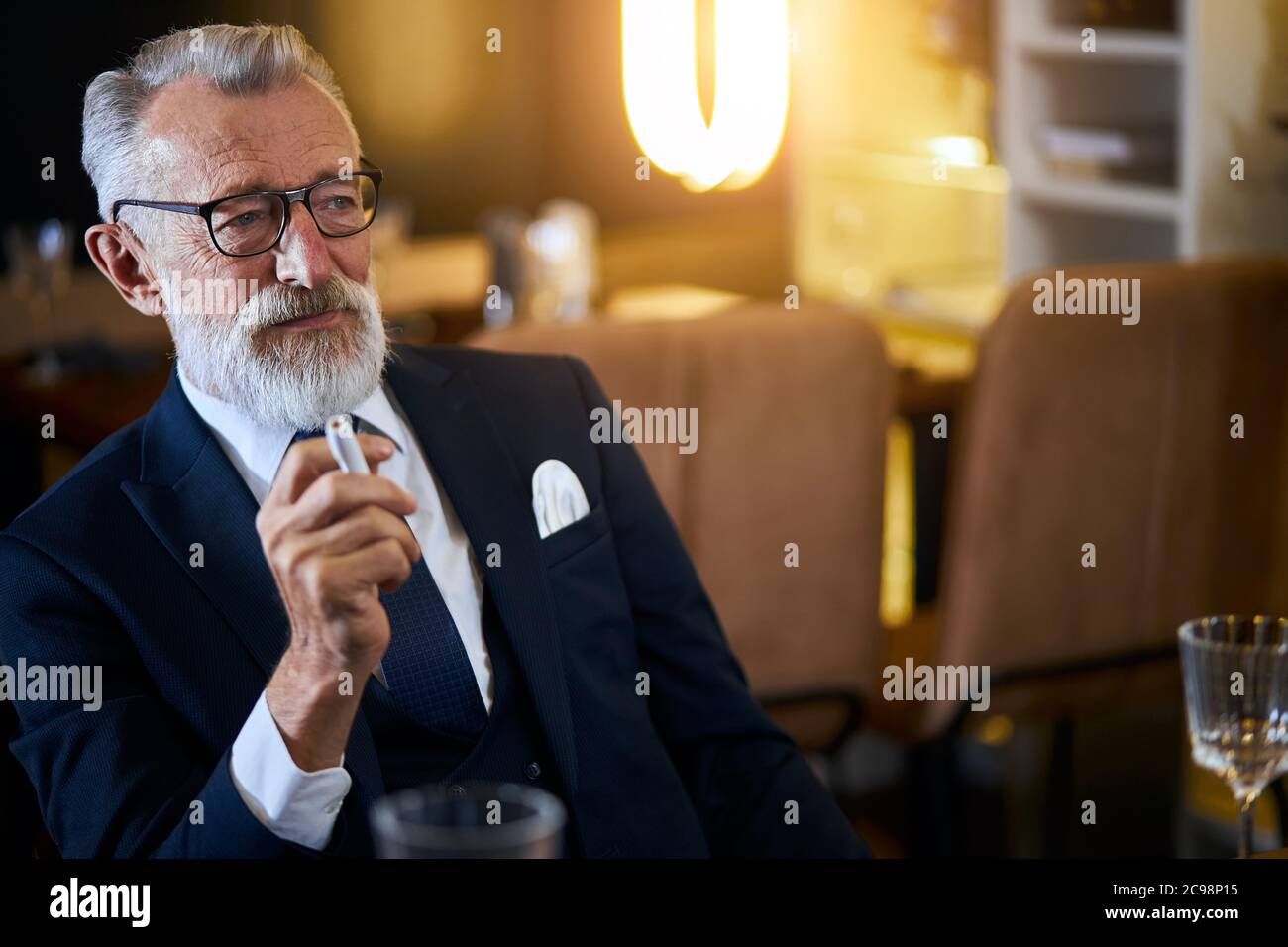 Elderly man vaping in closed public space. Smoking electronic cigarette ...