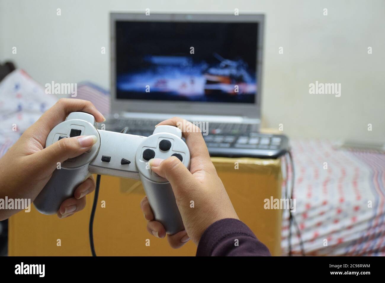 Play games at home using the joystick connected to the computer Stock ...