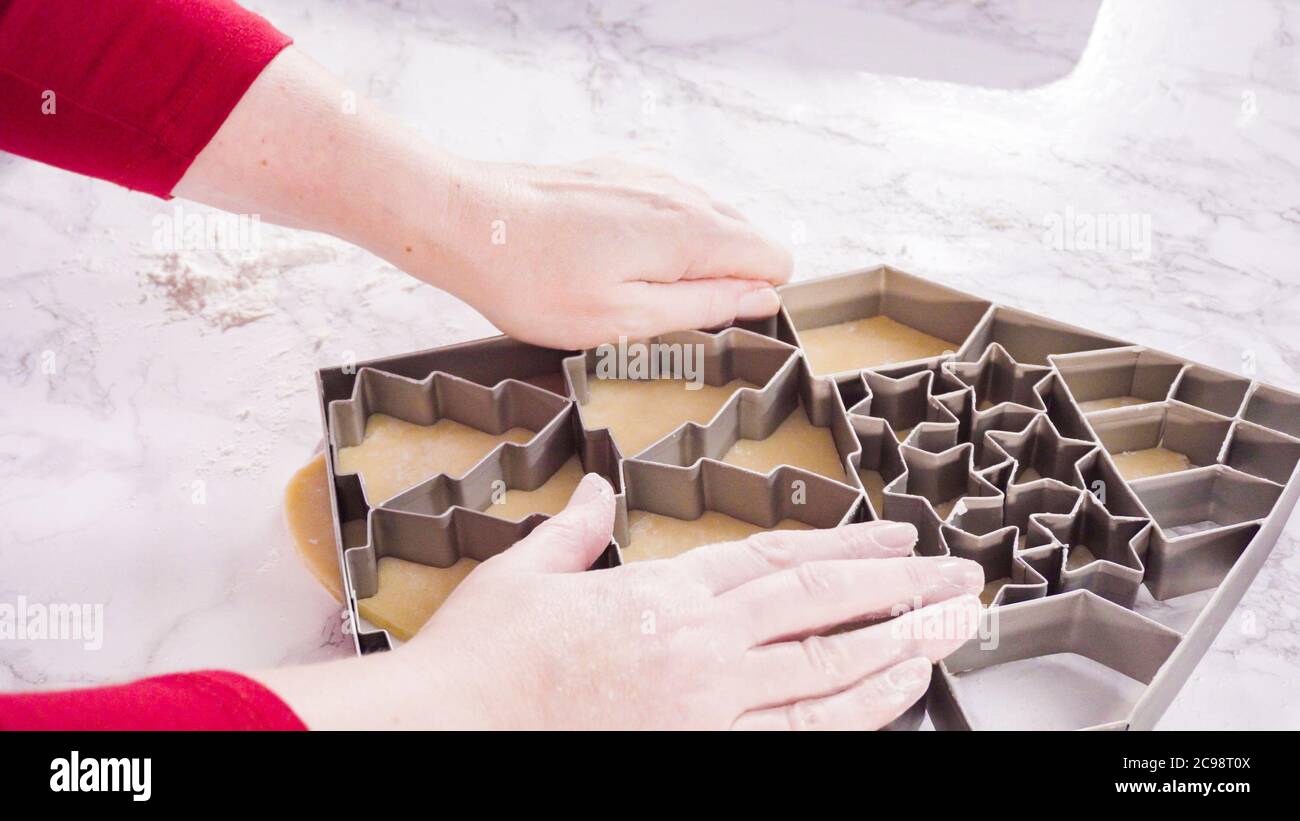 Cutting out sugar cookies with giant Christmas cookie cutter Stock ...