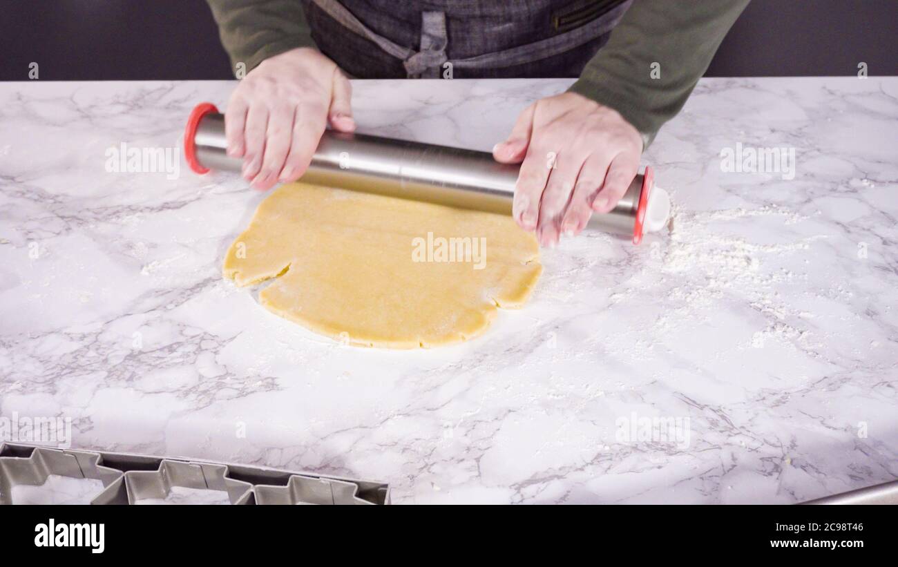 Step by step. Rolling out sugar cookie dough to bake Christmas cookies ...