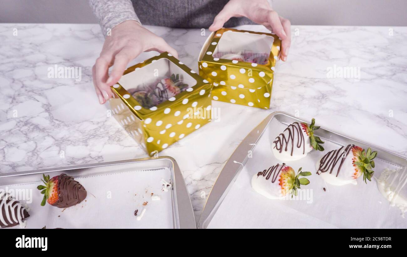 Step by step. Packaging chocolate dipped strawberries into a paper box ...