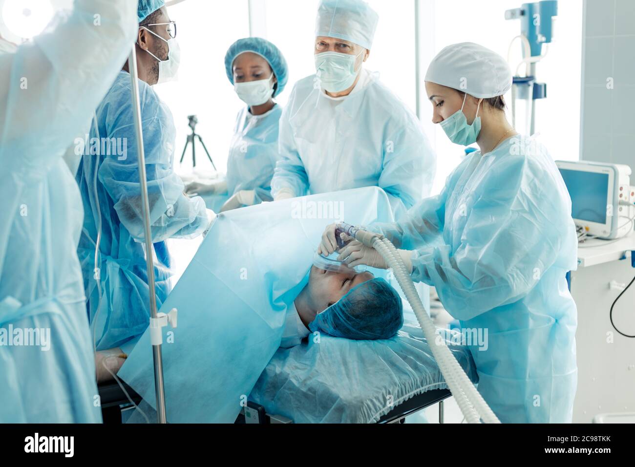 careful clever doctors adjusting oxygen mask on patient in hospital ...