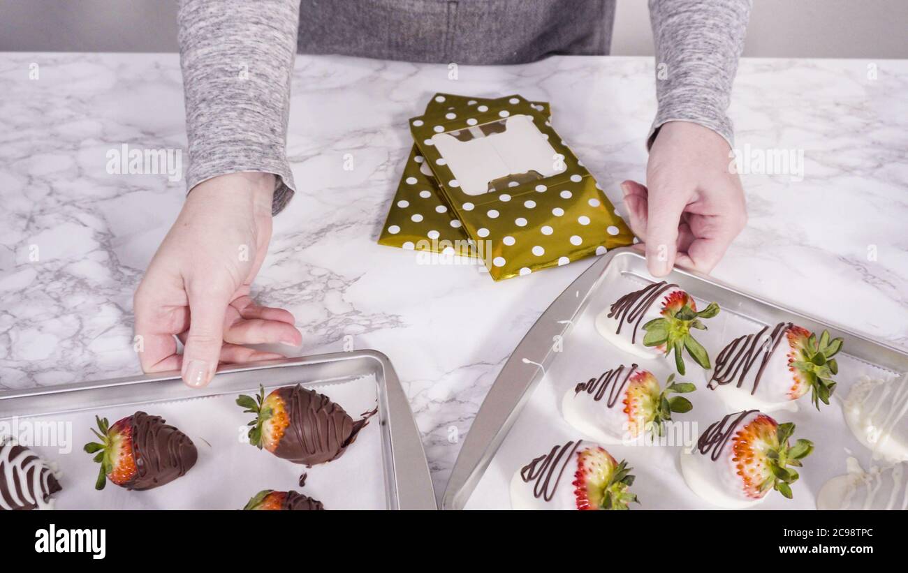 Step by step. Packaging chocolate dipped strawberries into a paper box ...