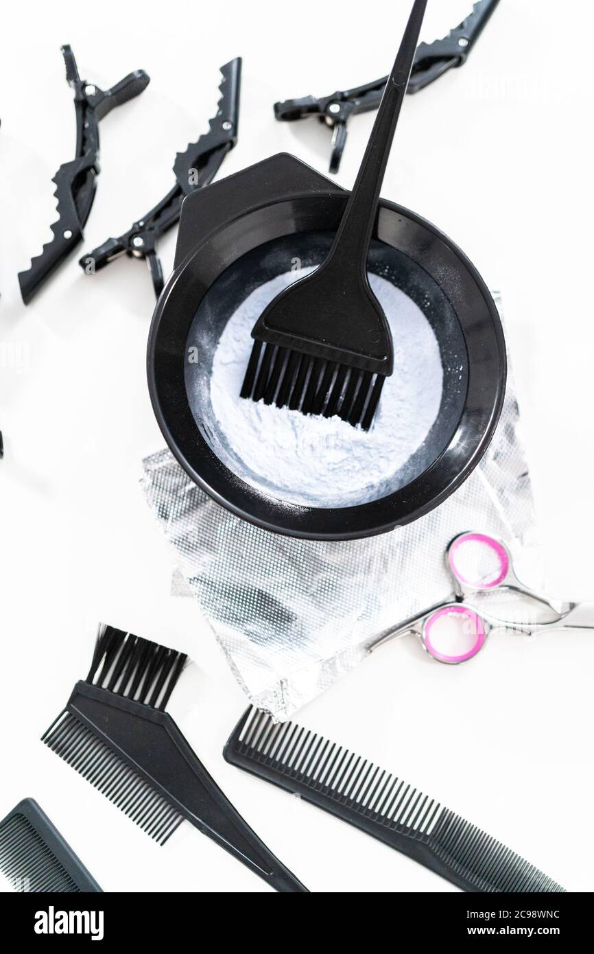 Hair color dye powder in a black plastic mixing bowl on a white ...