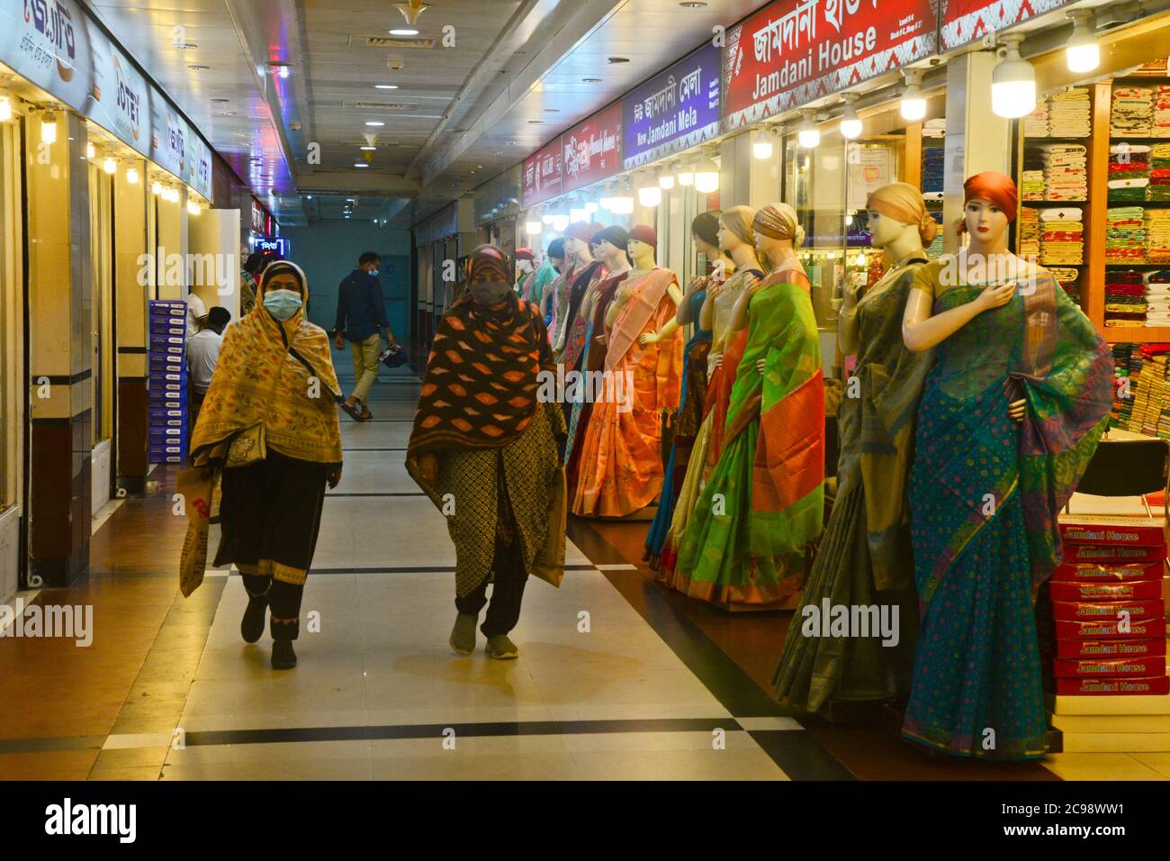 Bangladeshi shoppers wearing face mask to buy clothes at a shopping ...