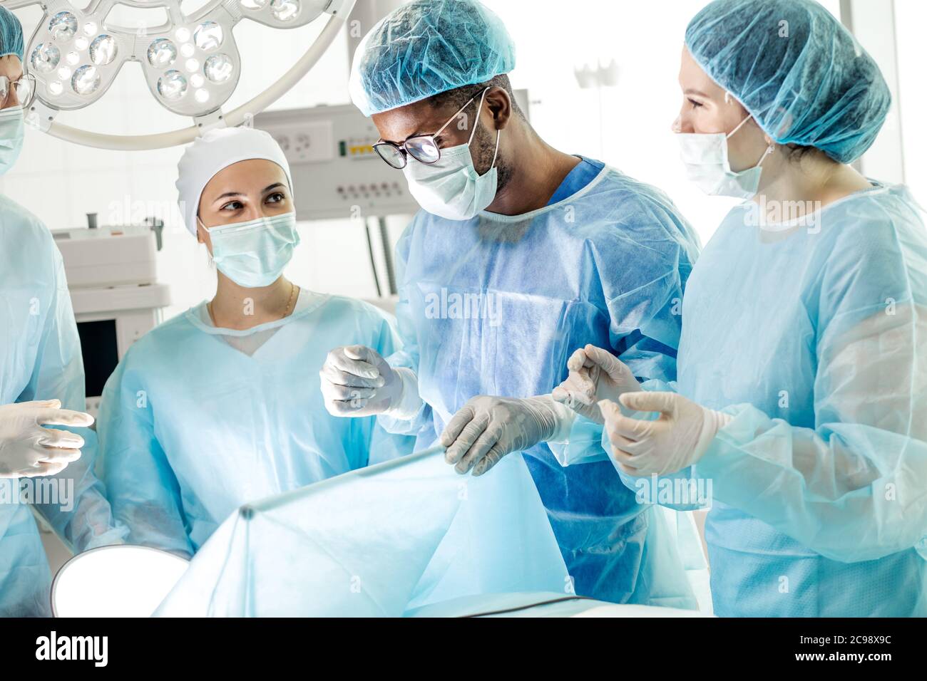 african talented successful surgeon giving advice to his assistants ...