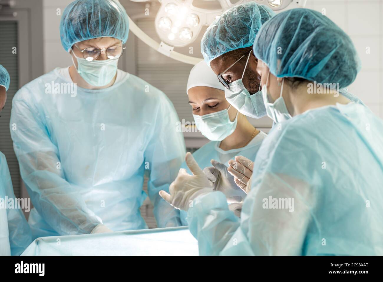 doctors and nurses providing treatment through an opening in the body ...