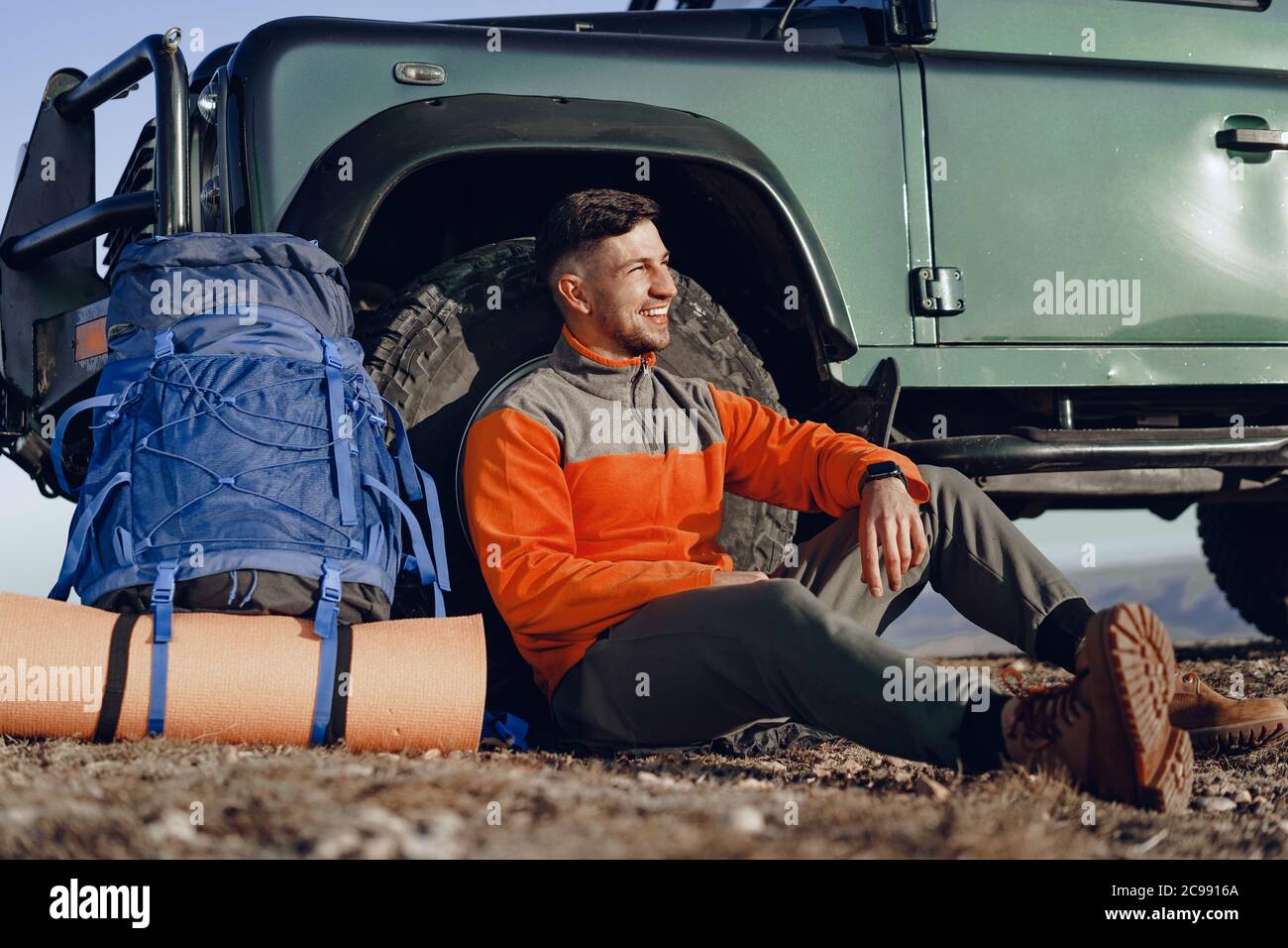 Young male hiker sitting and having a rest on a halt stop Stock Photo ...