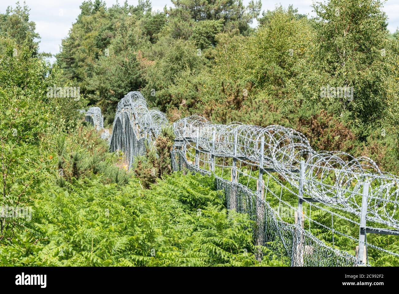 Fence with barbed wire around army or miltary land, UK Stock Photo - Alamy