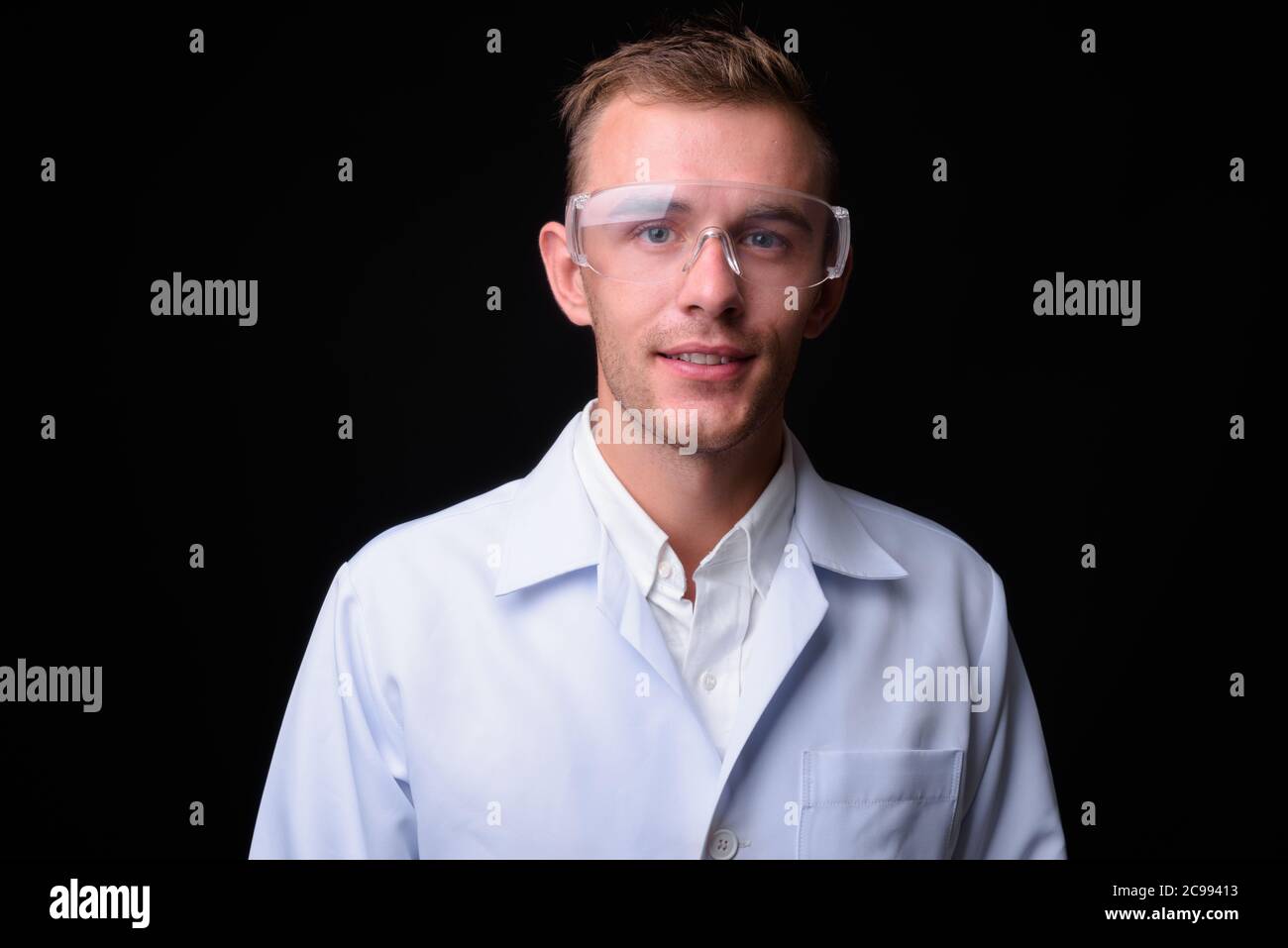 Portrait of young handsome man doctor as scientist with protective ...