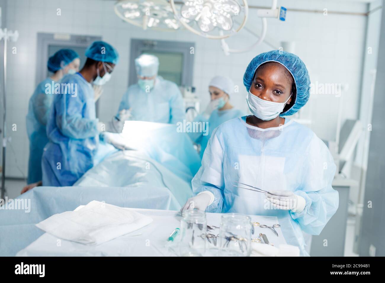 good looking american doctor holding forceps and posing to the camera ...