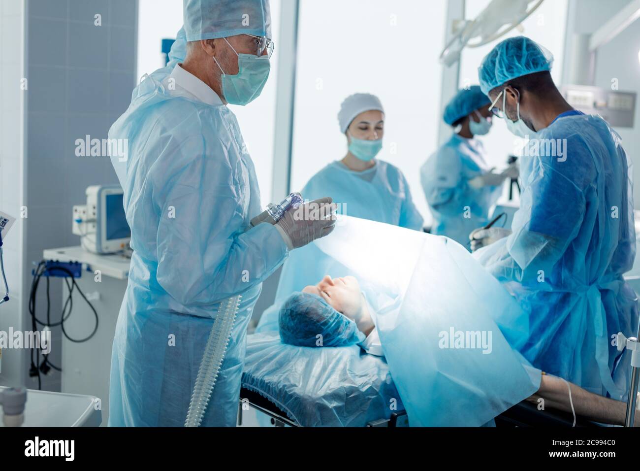 male patient lying on an operating table with surgeons in a surgery ...