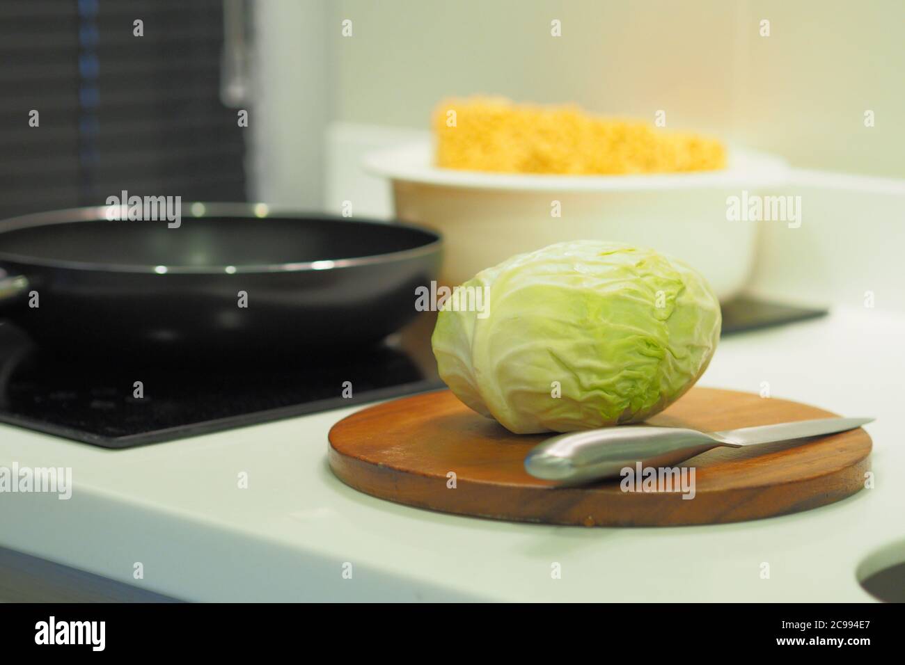 The chef is facing the cabbage on the cutting board in the kitchen ...