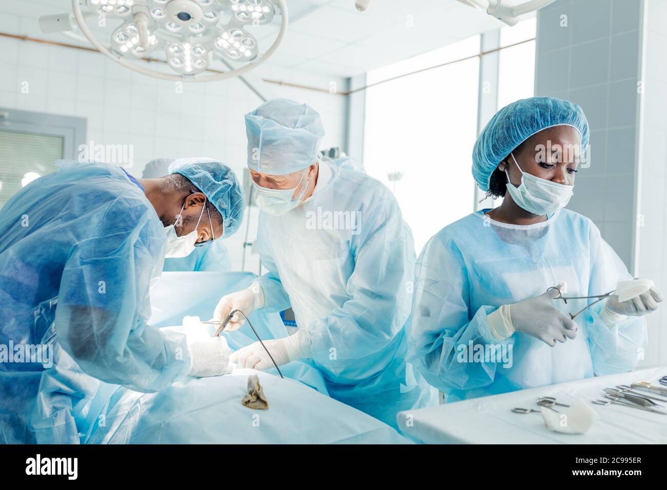 multiracial doctors having the surgery in the operating room Stock ...