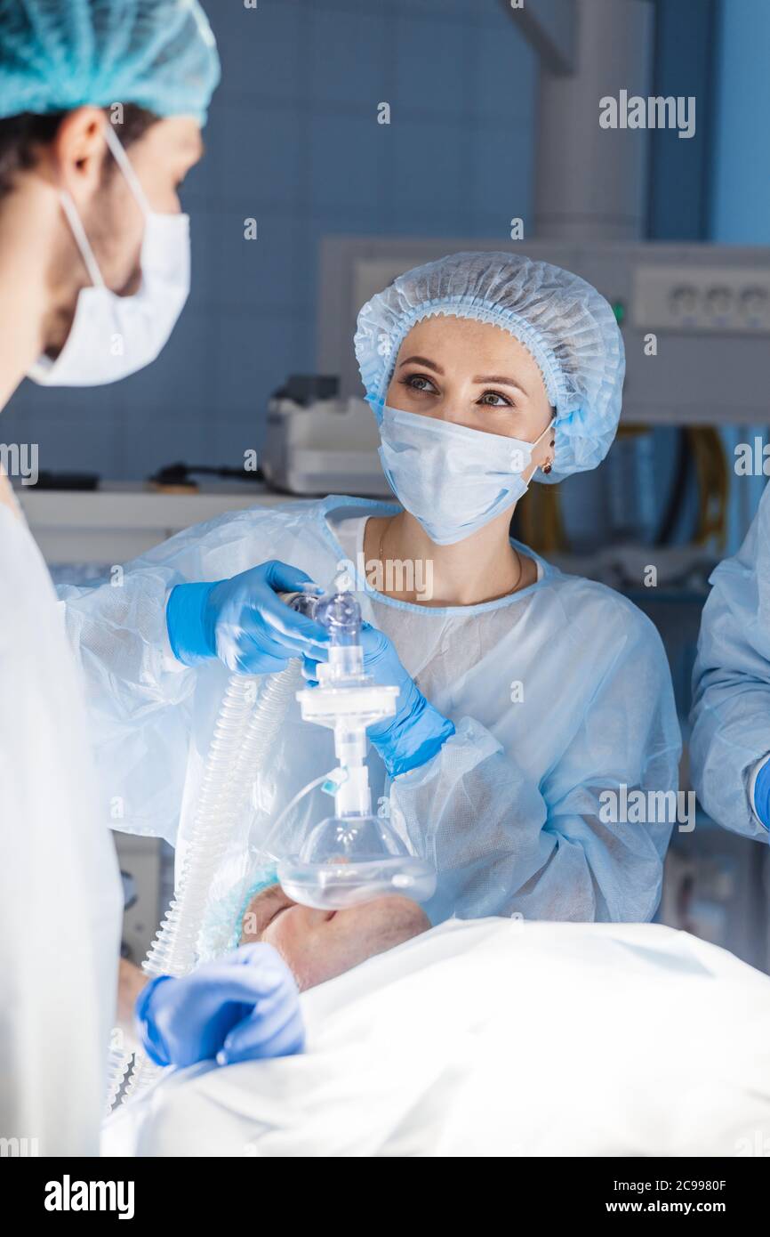 Team of experienced doctor and female assistants preparing diseased man ...