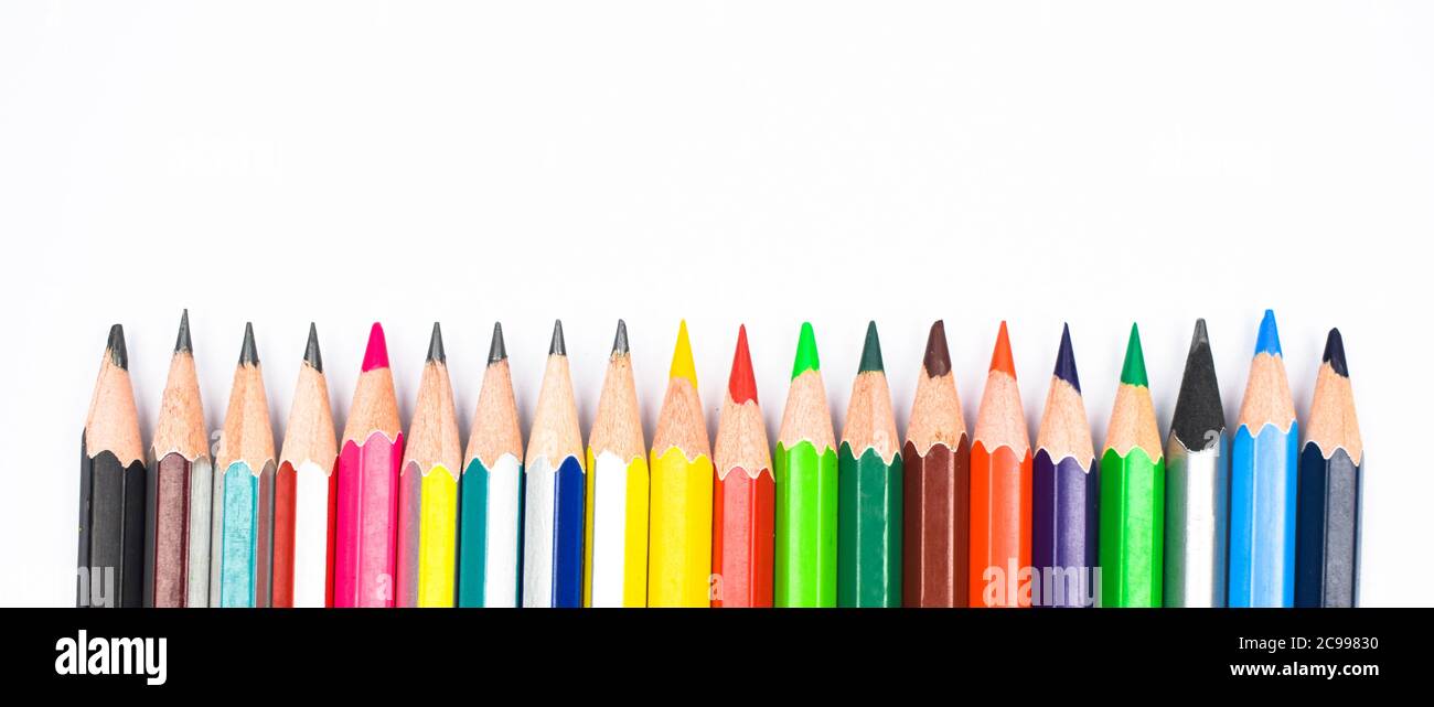 A line of different colored wood pencil crayons placed on an isolated ...
