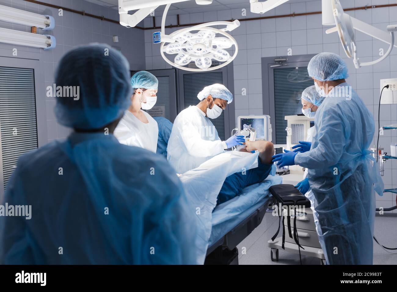 Photo of anesthesiologist with mask preparing patient to the surgery in ...