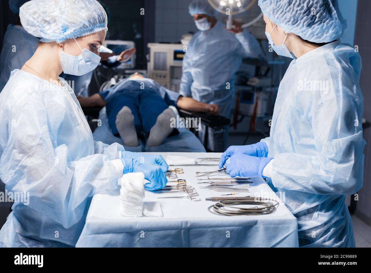 Two young Asian and Caucasian female assistants preparing surgical ...