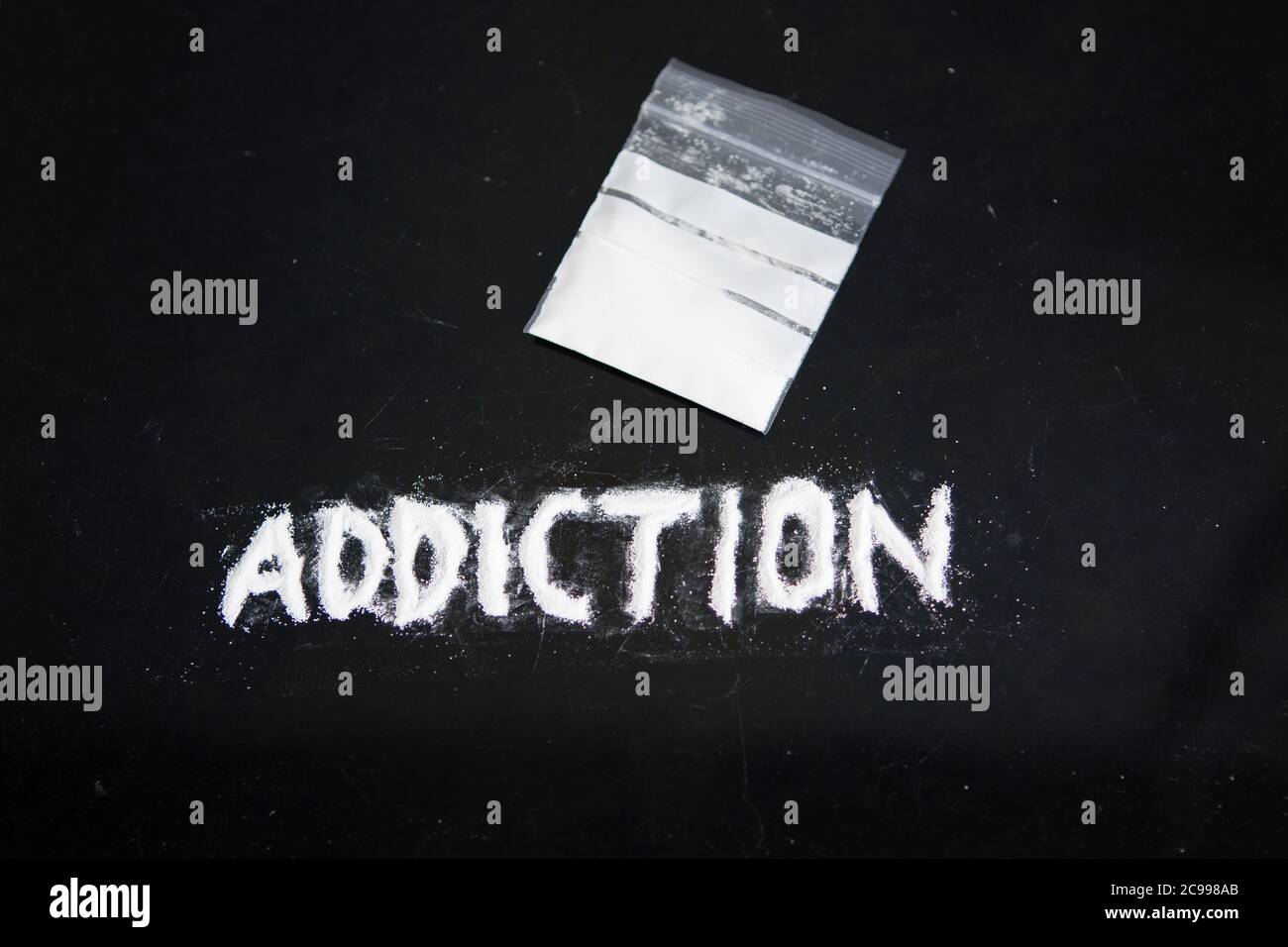 Cocaine powder and drugs in plastic bags on black glass surface. Drug ...