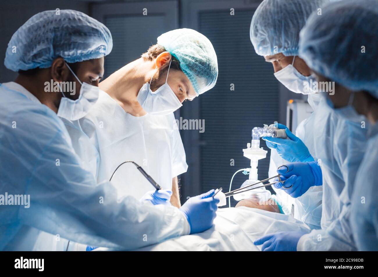 Surgeons in operating theatre performing hi-res stock photography and ...