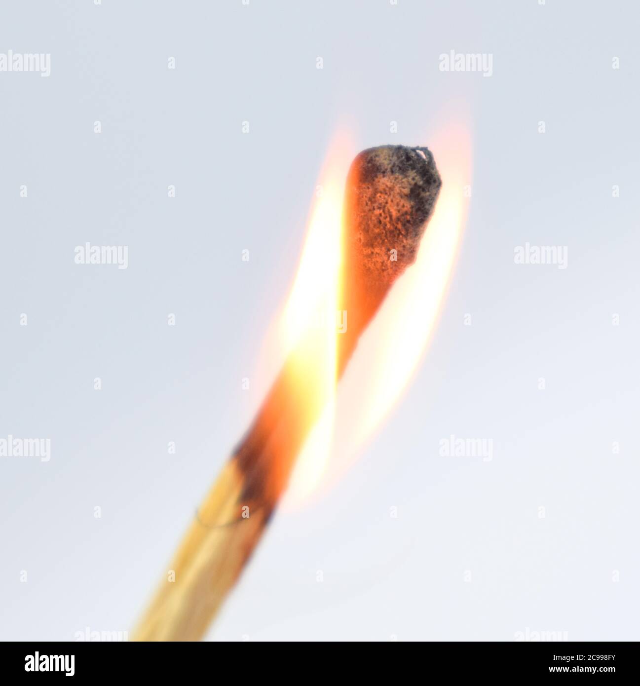 Flaming match stick burning in the middle of a very white isolated ...