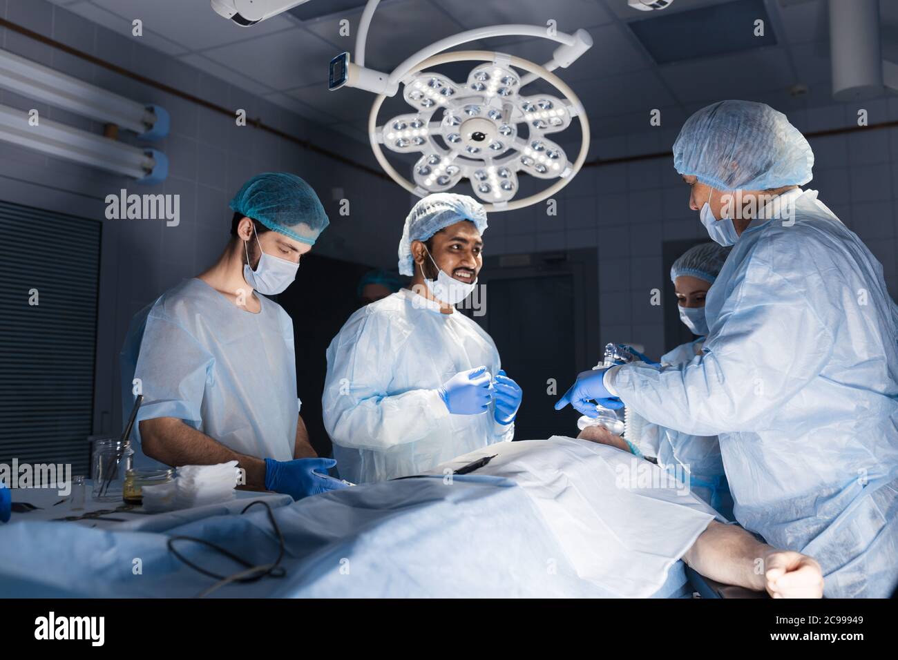 Multiracial Team of Surgeons concentrating on a patient during a heart ...
