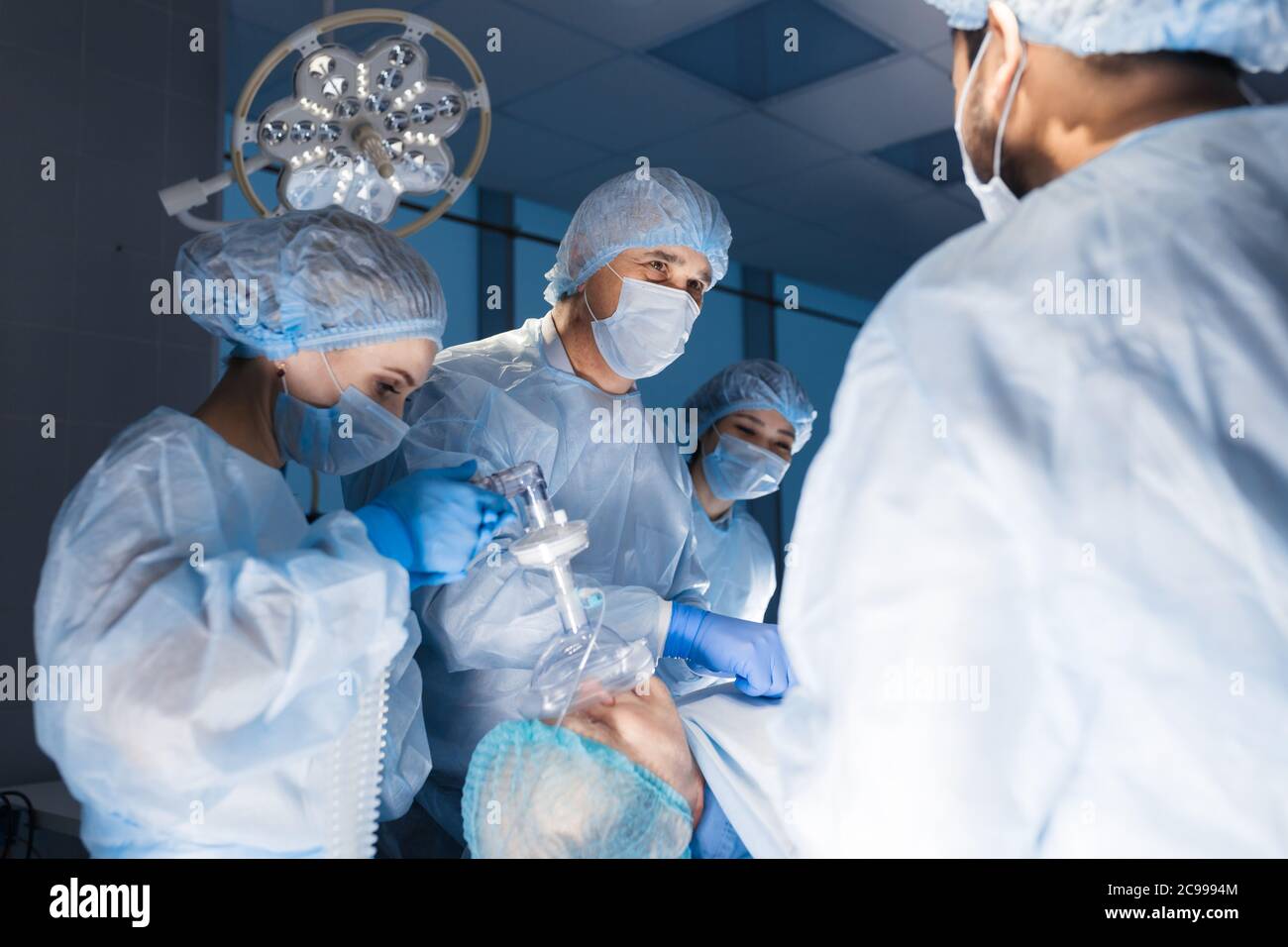 Multiracial Team of Surgeons concentrating on a patient during a heart ...