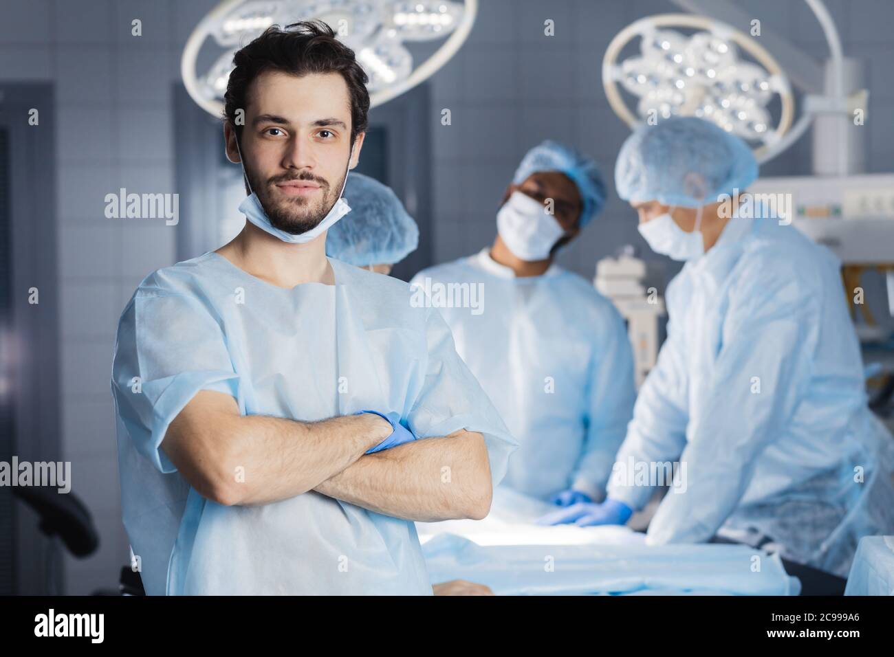 Portrait of young handsome successful surgeon doctor with his ...