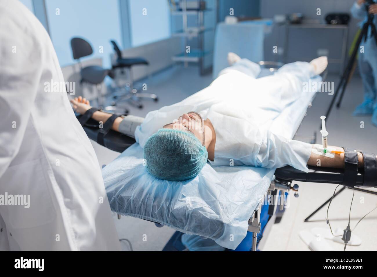 Male Patient with needle of the syringe is plugged into an intravenous ...