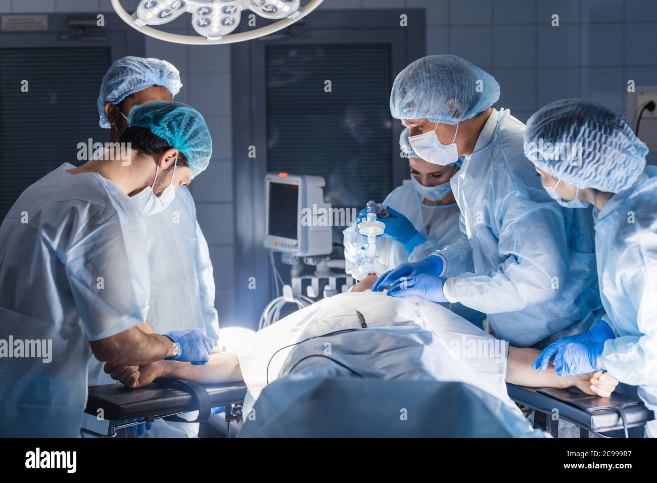 Team of experienced doctors and assistants performing difficult ...