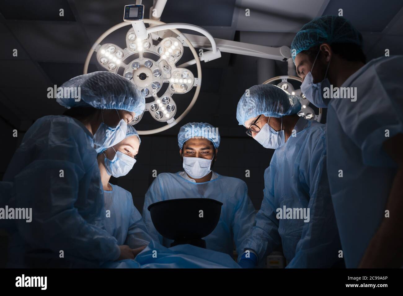 Low angle view of team of professional surgeons working at the hospital ...
