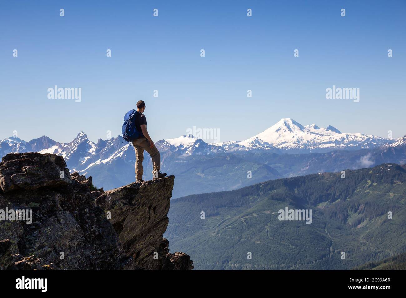 Man on the Edge of a Cliff looking at Canadian Landscape Stock Photo ...