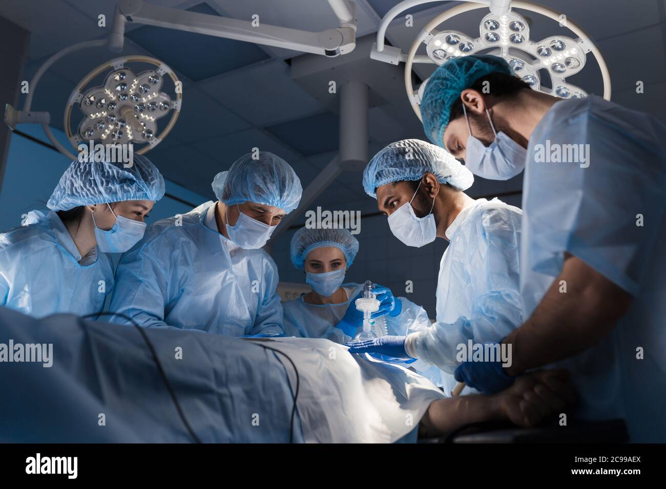 Urgent surgery. Professional smart intelligent surgeons standing near ...