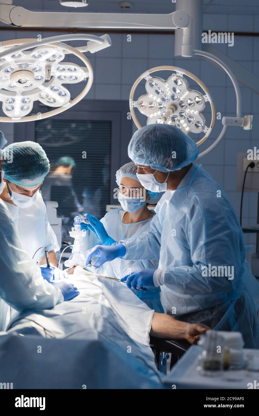 Complex surgery. Skilful surgeon works with scalpels and clamps during ...
