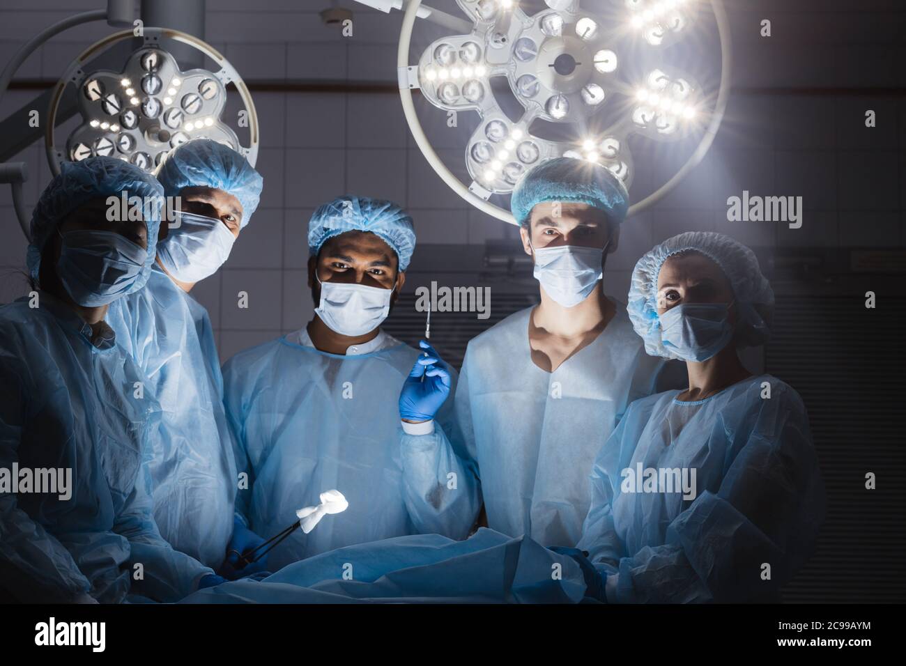 Hospital concept. Surgery team looking at camera in the operating room ...