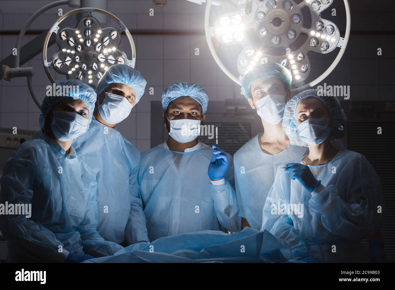 Hospital concept. Surgery team looking at camera in the operating room ...