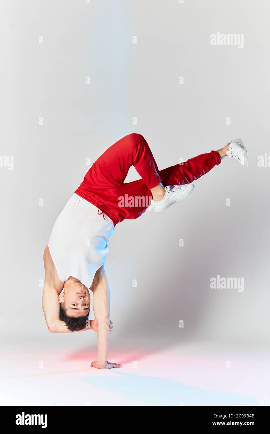 Free style dancer in red sports trousers doing some acrobatic stunts ...