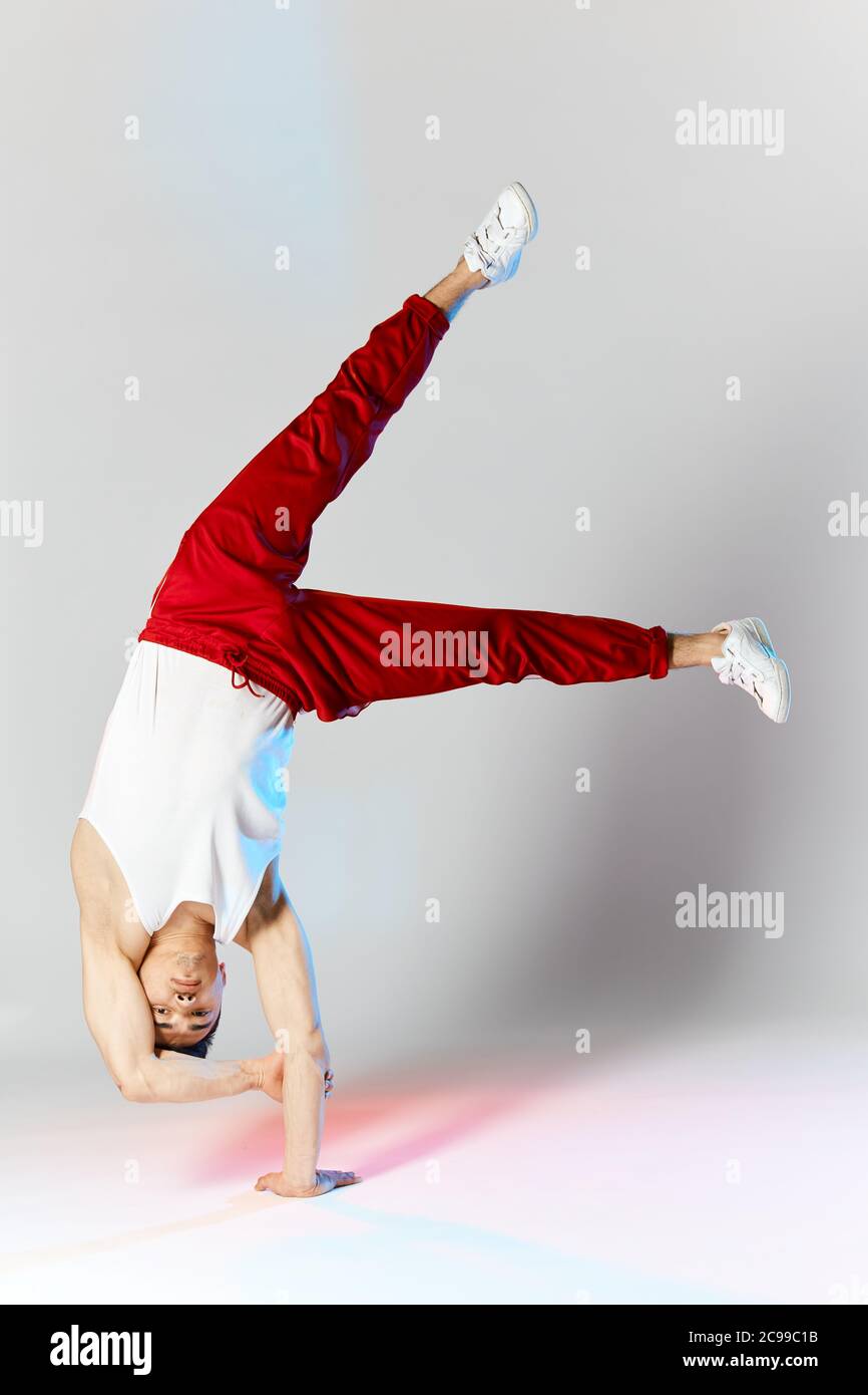 Chinese break dancer in red sweatpants showing his skills on white ...