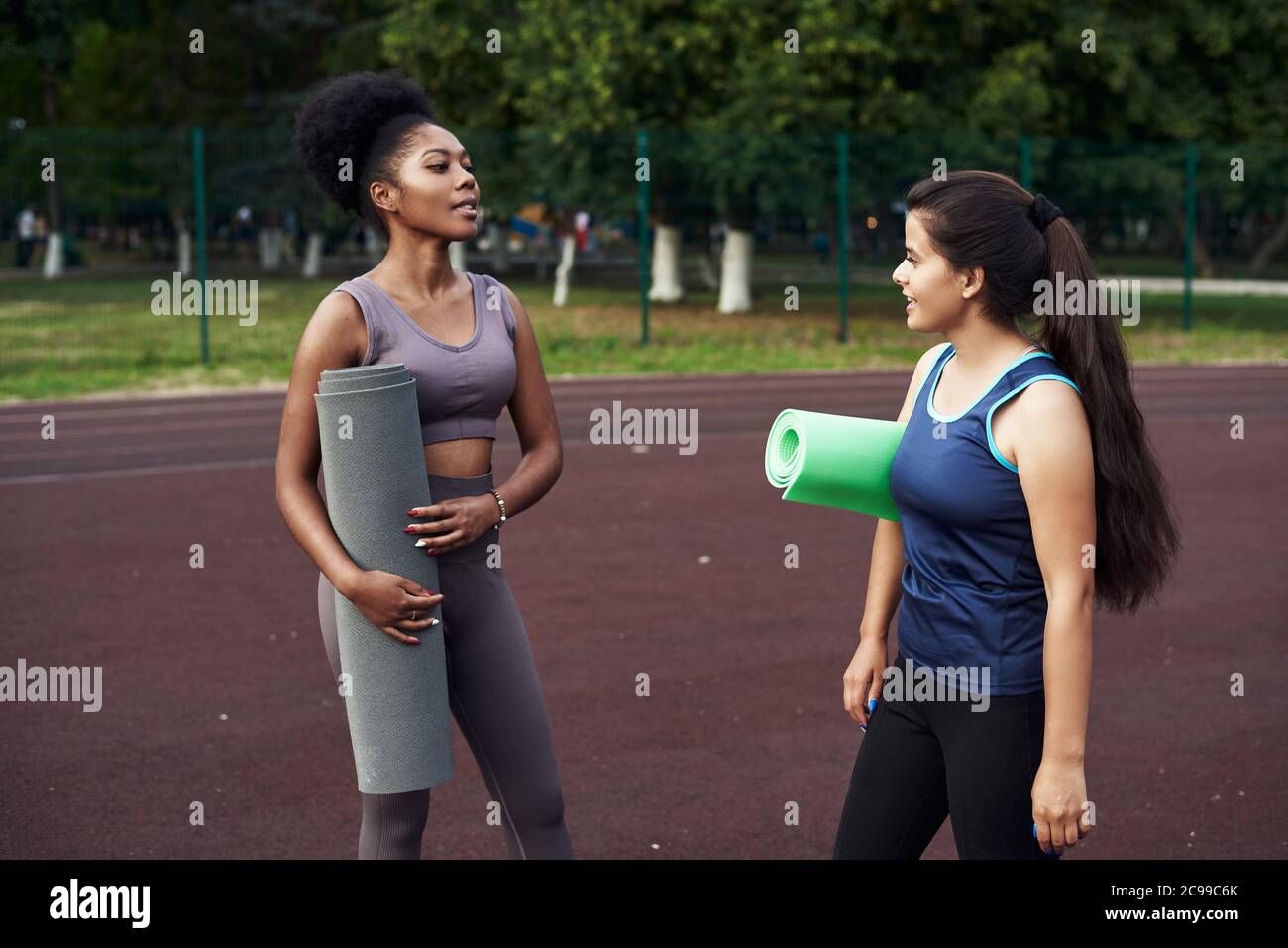 Two young beautiful girlfriends are talking about the past workout ...