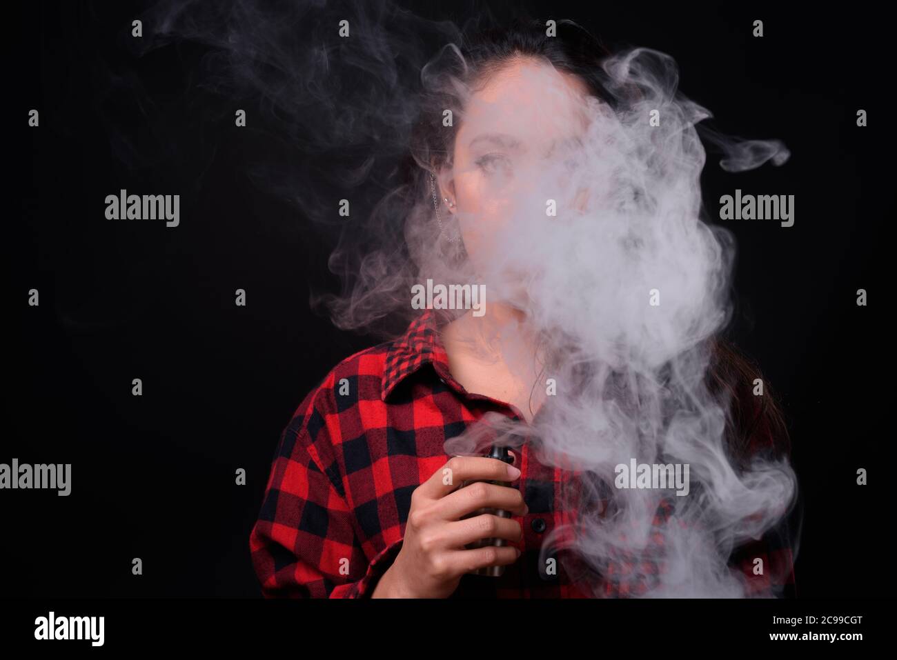 Young beautiful Asian woman vaping against black background Stock Photo ...