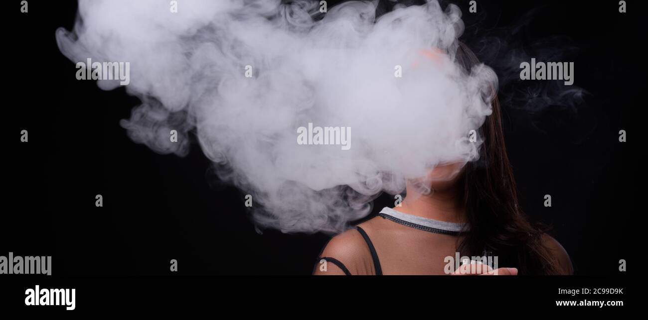 Young beautiful Asian woman vaping against black background Stock Photo ...