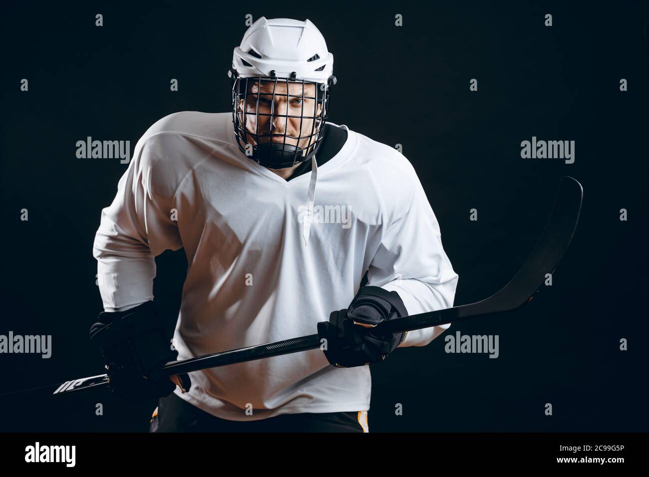 Image of ice-hockey player in white sportswear holding hockey stick ...