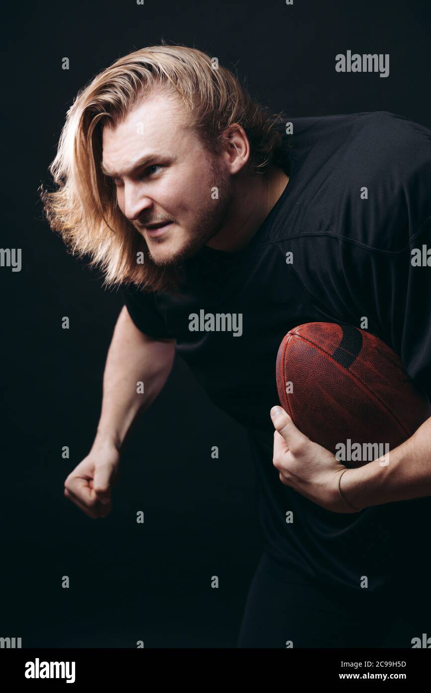 American football team captain posing in motion with ball isolated on ...