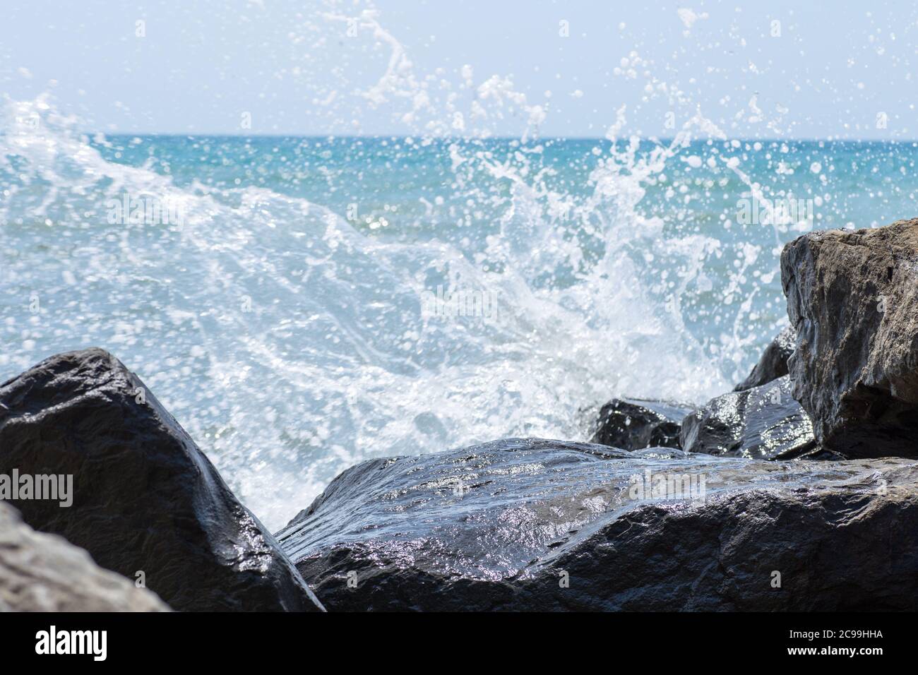 Balance zen stones pyramid on pebble beach with a splashing wave ...