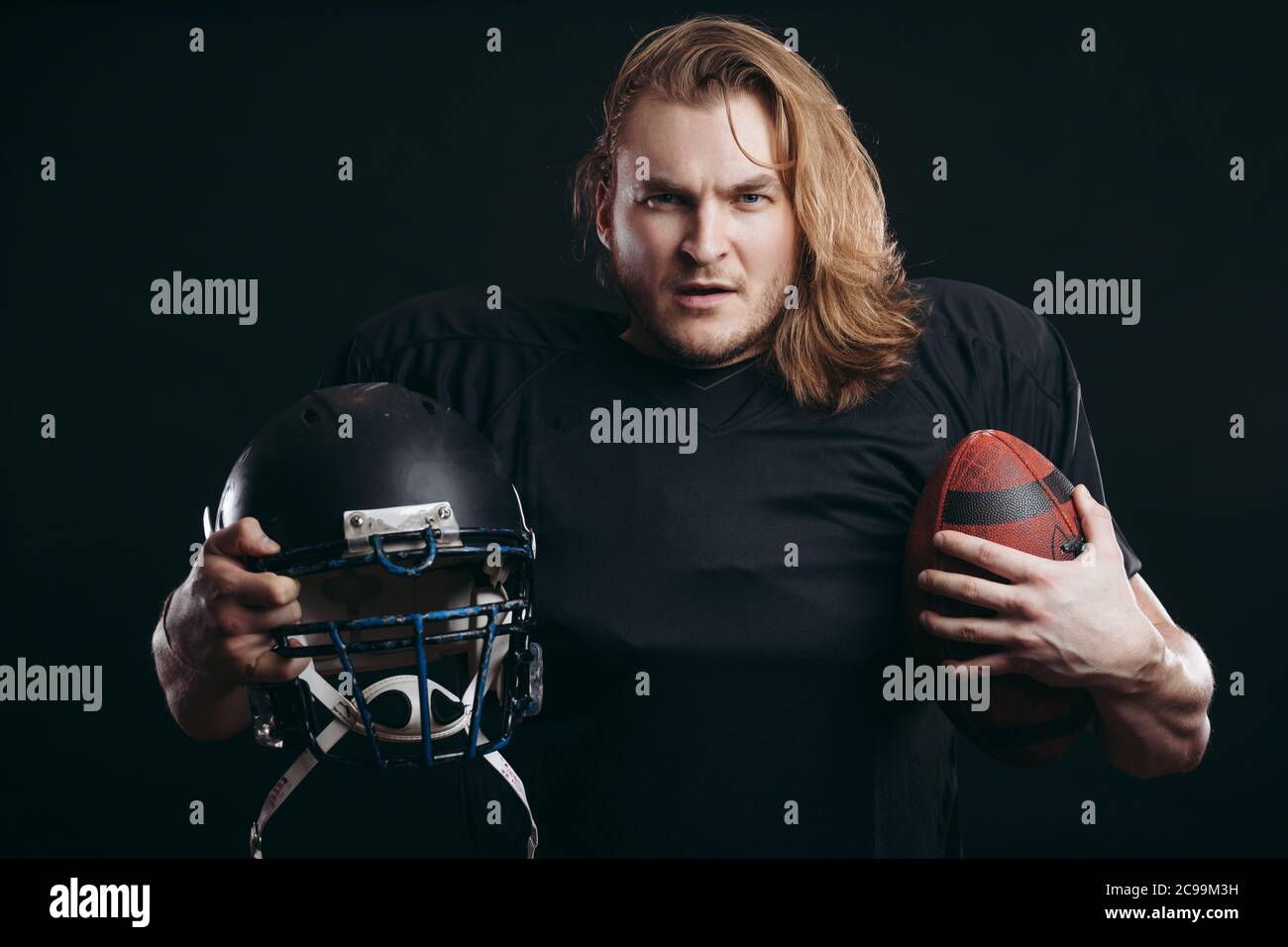 American football team captain posing in motion with ball isolated on ...